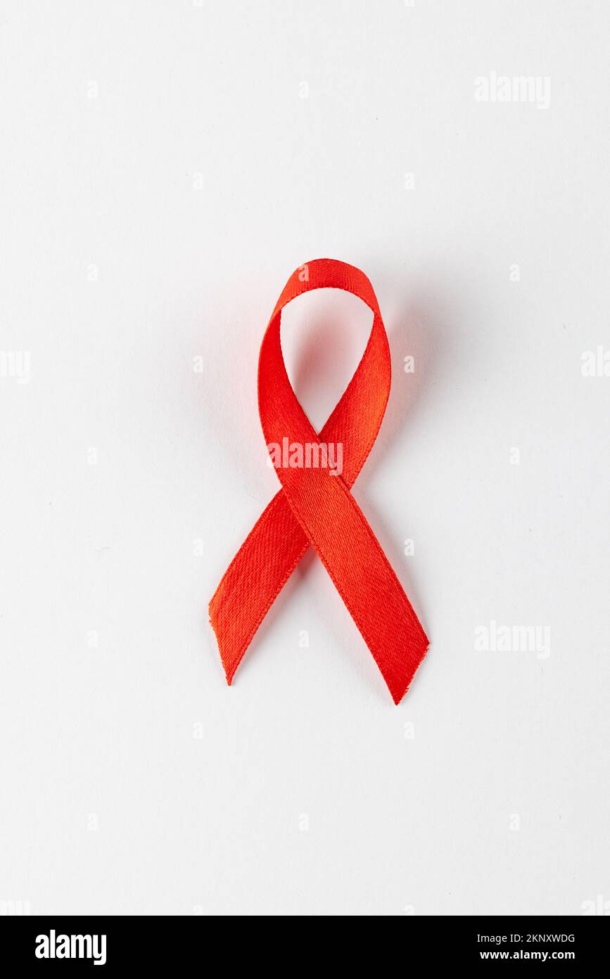 Vertical composition of red ribbon for hiv or aids awareness, on white background with copy ...