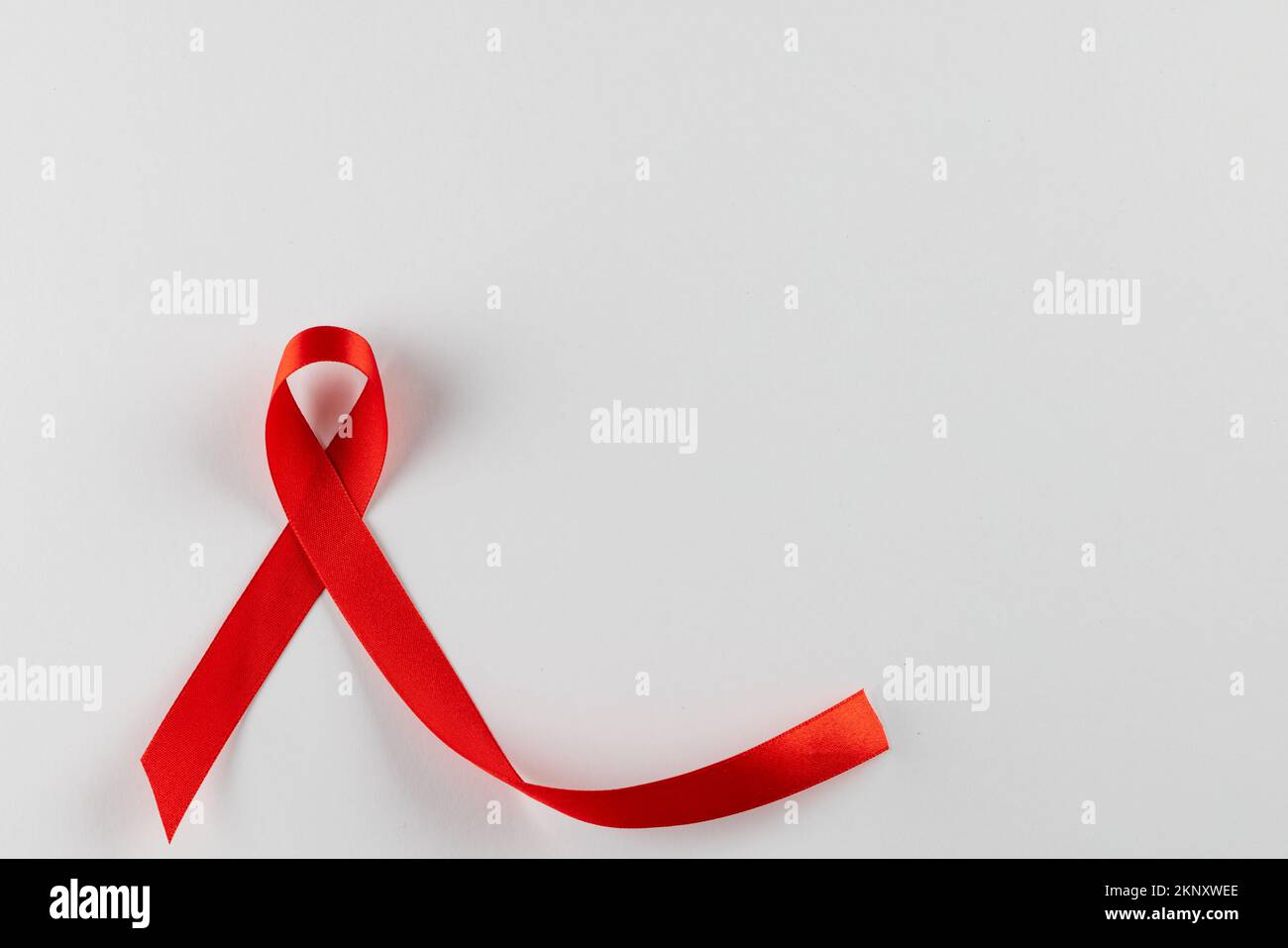 Composition of red ribbon for hiv or aids awareness, on white background with copy space Stock ...