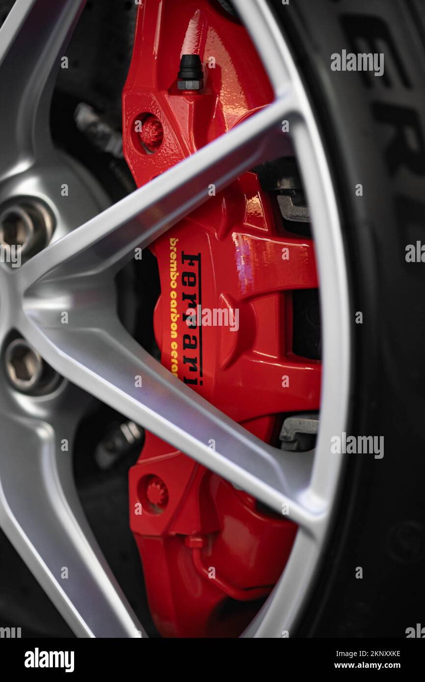 A closeup of a Ferrari silver wheel and a red carbon-ceramic brake ...