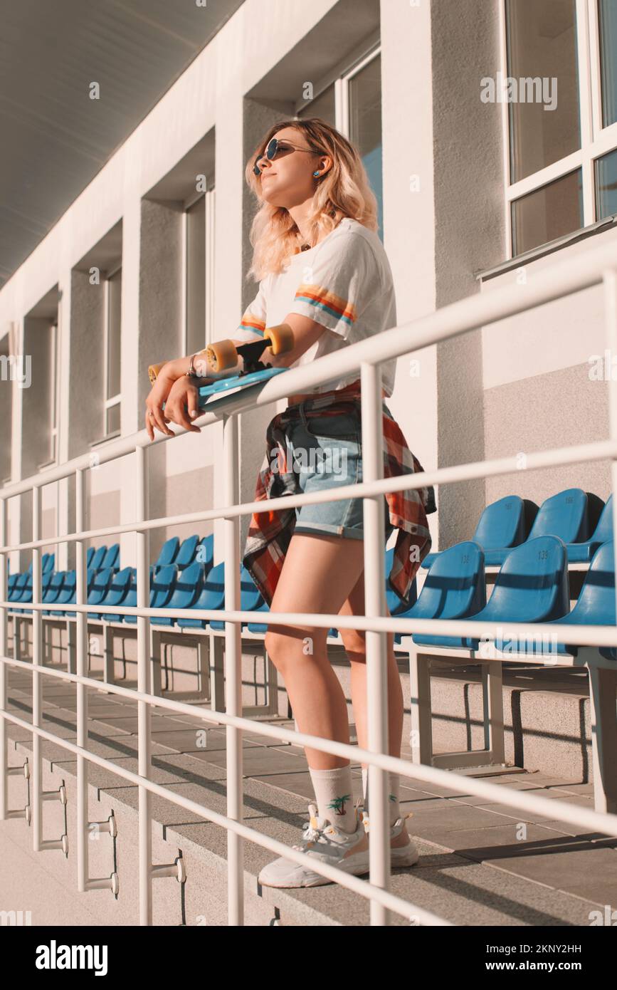 Stylish young casual woman in sunglasses shorts and a white T-shirt ...