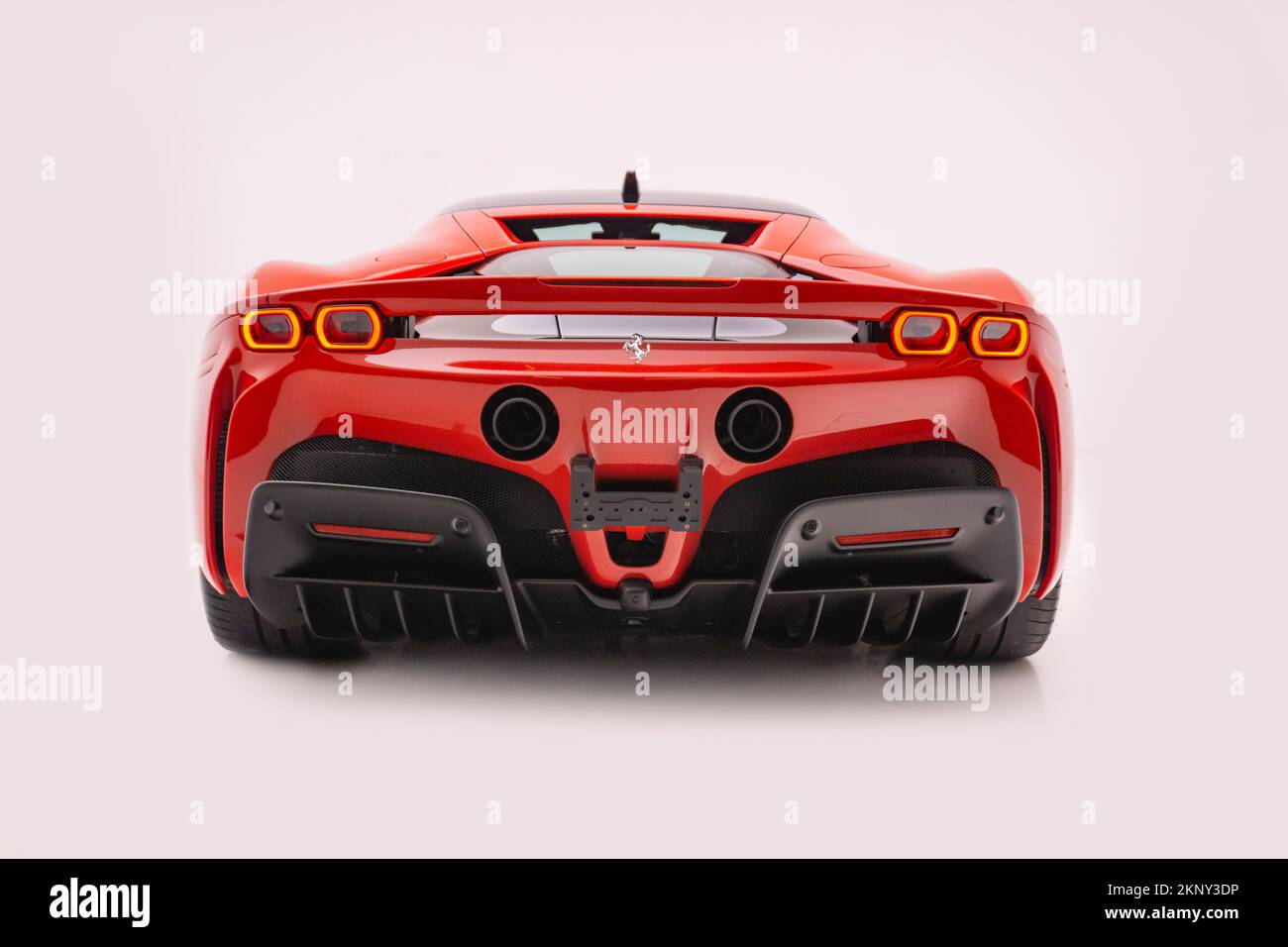 The rear end of a red Ferrari SF90 Stradale in a studio, on white ...
