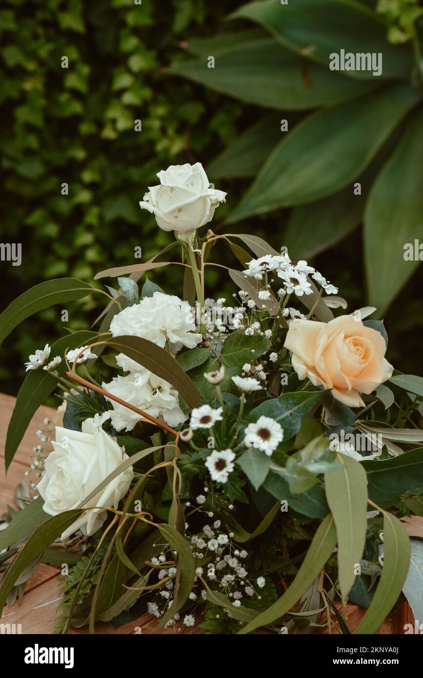 A closeup shot of colorful garden roses bouquet with green plants in ...
