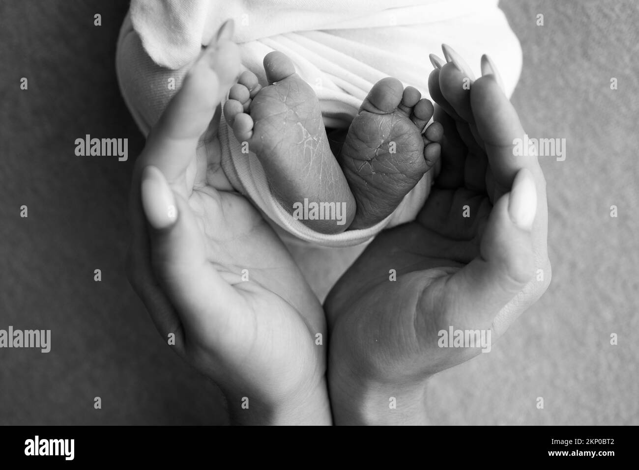 The palms of the father, the mother are holding the foot of the newborn ...