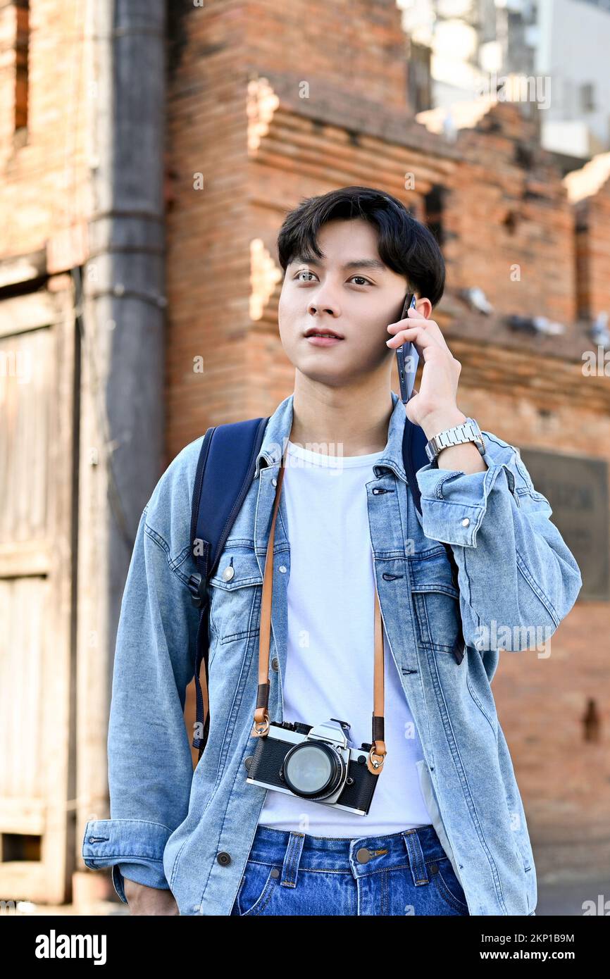 Portrait, Handsome young Asian male traveler or tourist talking on the ...
