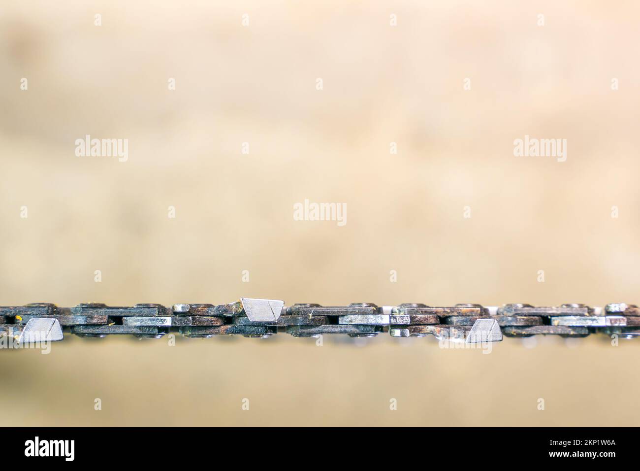 Saw chain on a chainsaw bar close-up on a blurred background, top view ...