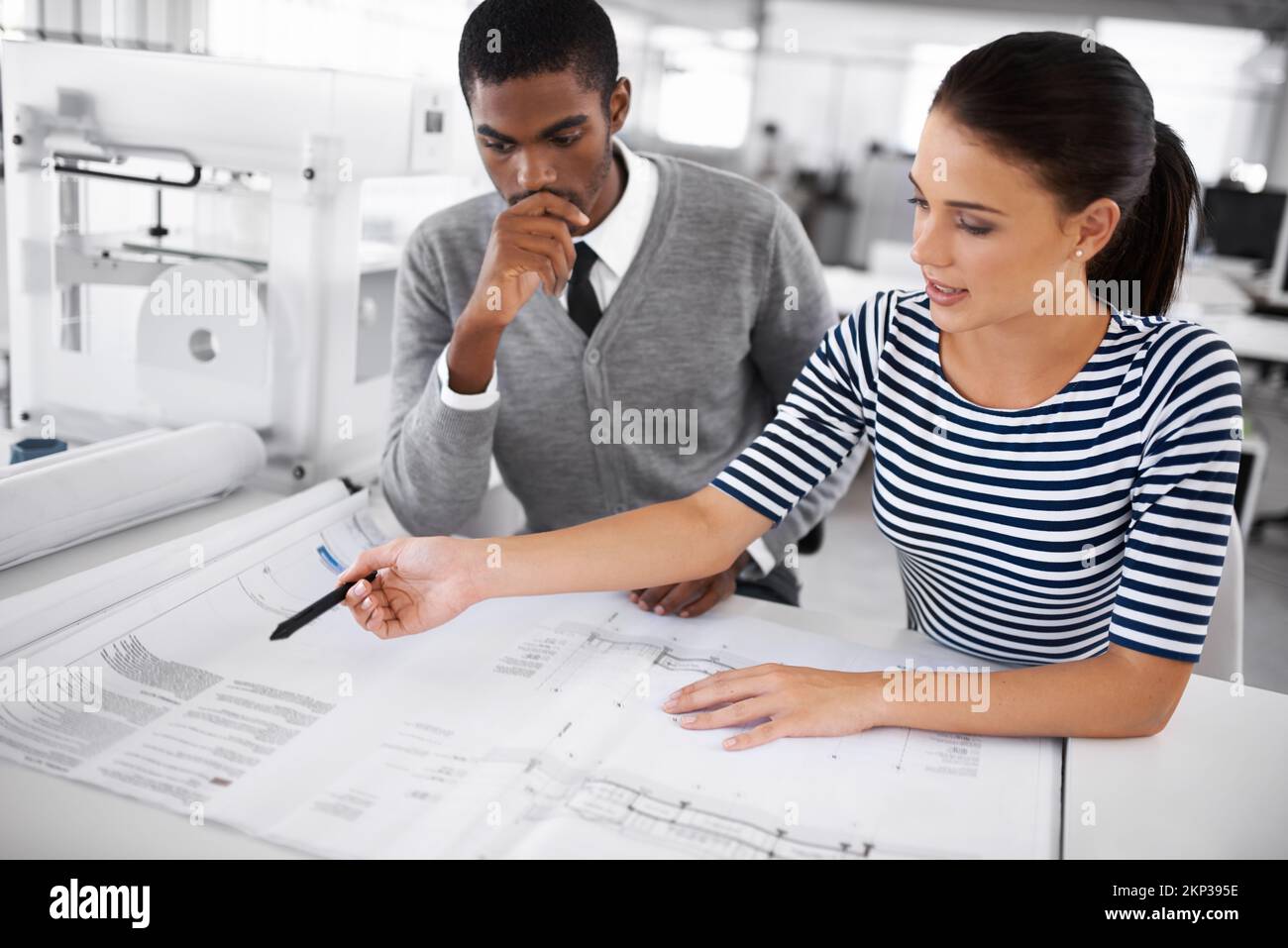 Checking every little detail. two designers going over blueprints Stock ...