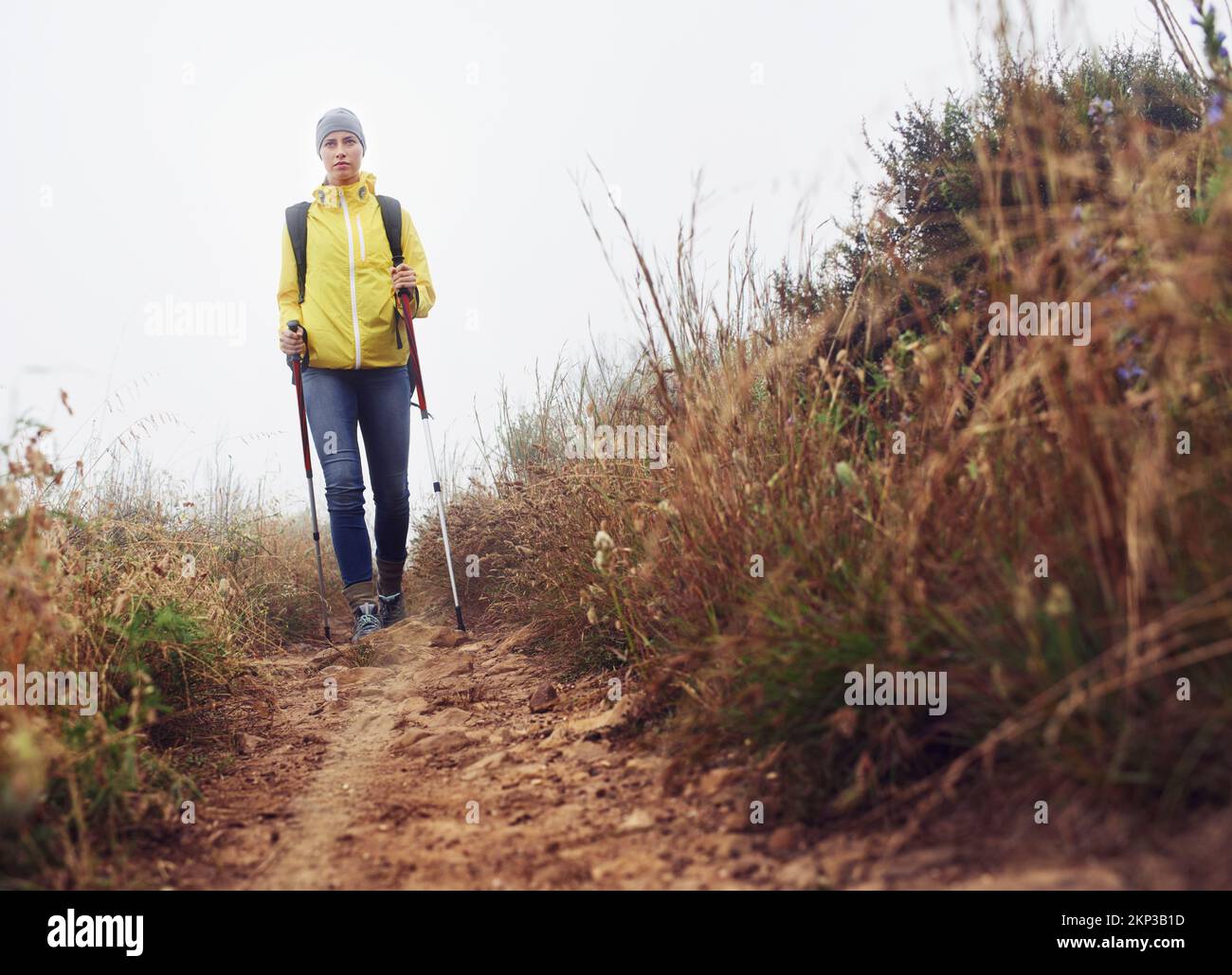Shes fearless. Low-angle view of a female hiker walking along a hiking ...
