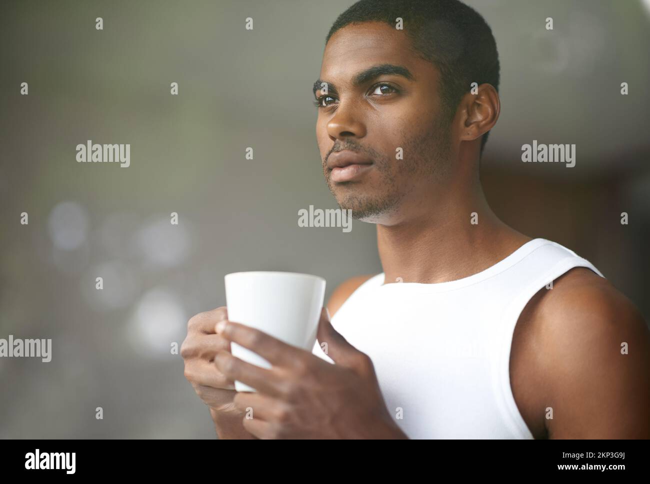 Starting off the morning with a cuppa joe. a young man holding a cup of ...