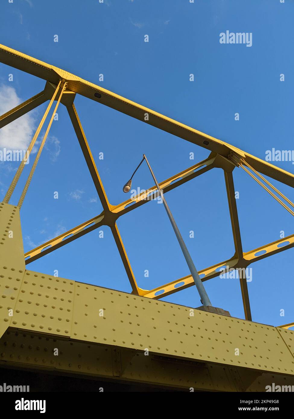 Yellow Steel Bridge Looking Up Contrast With Blue Sky Stock Photo - Alamy