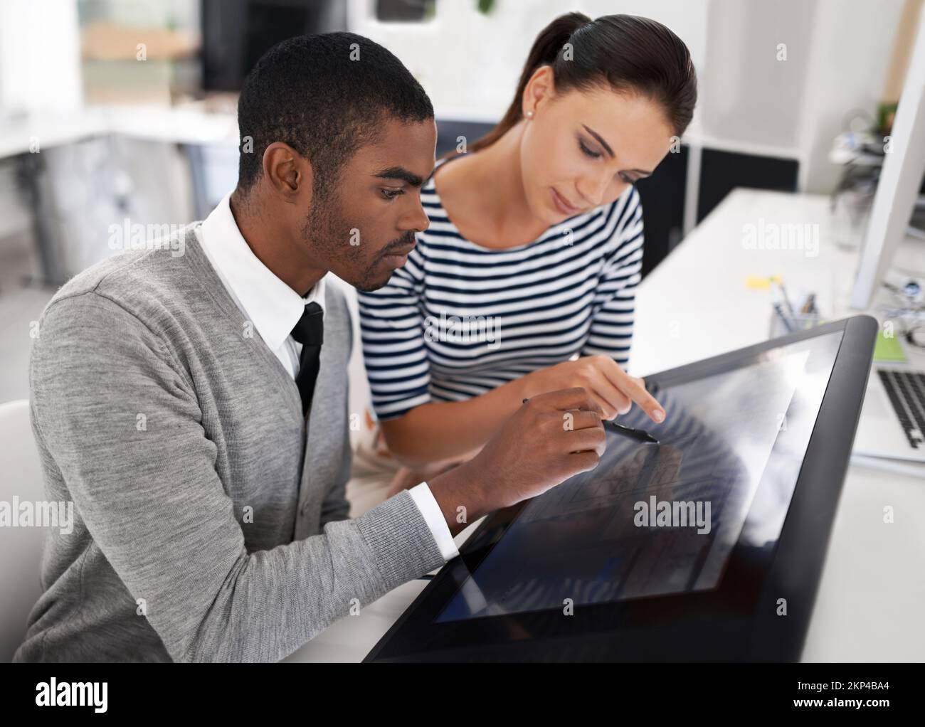 Working with the latest tech. two designers using a large touchscreen ...