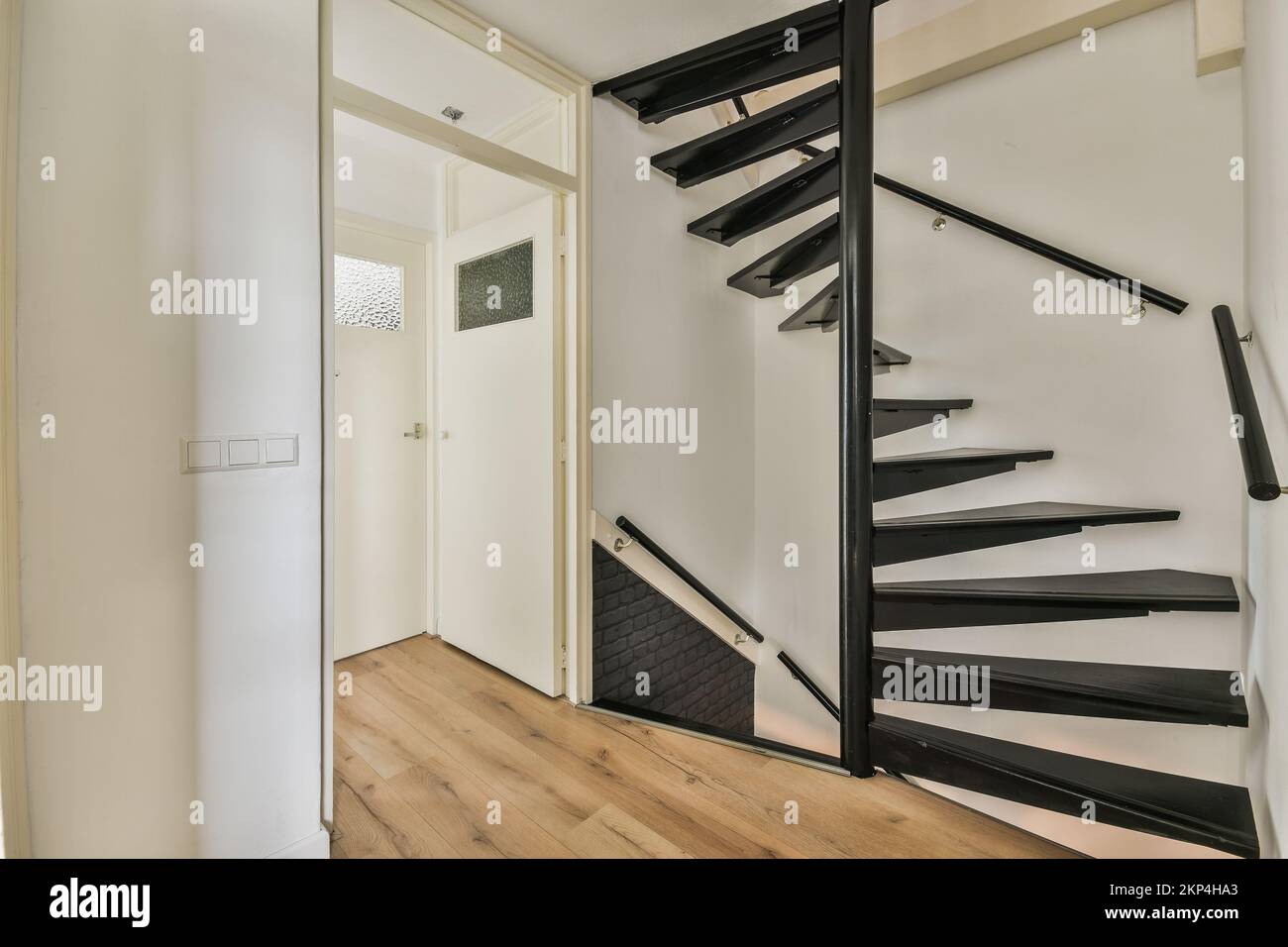 From above of narrow spiral stairway with white stairs and railing on ...