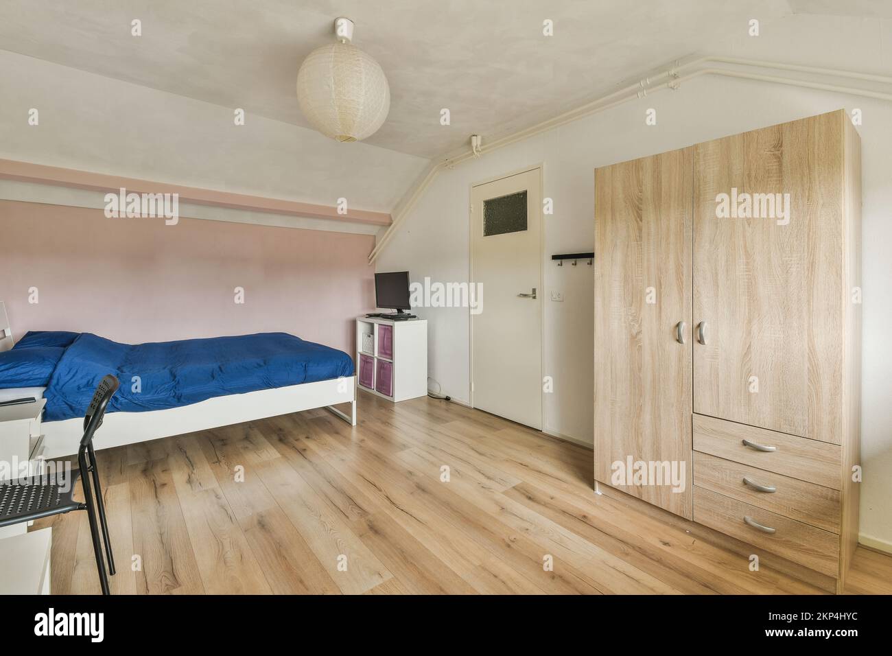 Comfortable bed located near window with curtain in light bedroom with ...