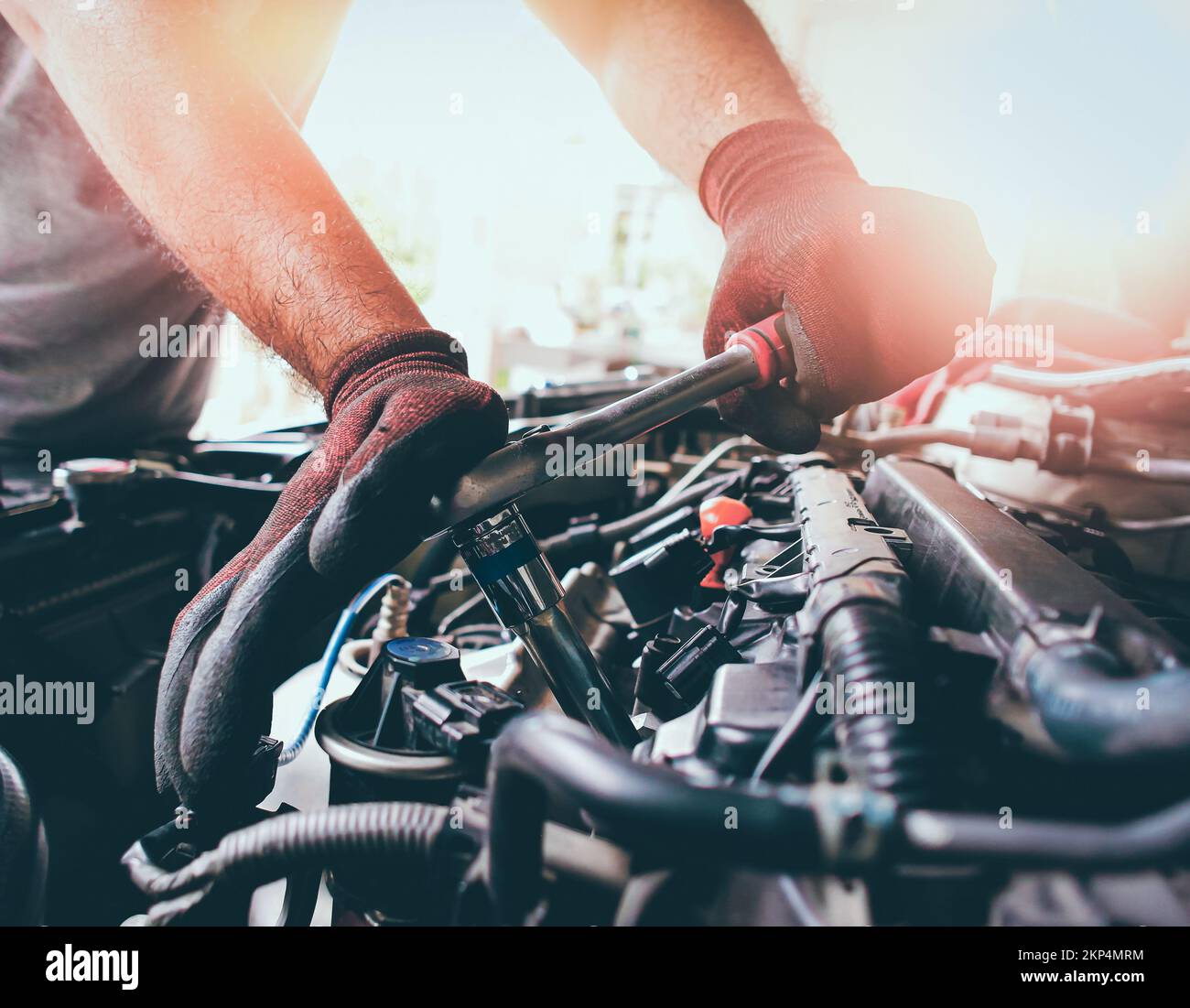 The red gloved hand of the auto mechanic is fastening the bolt with the ...