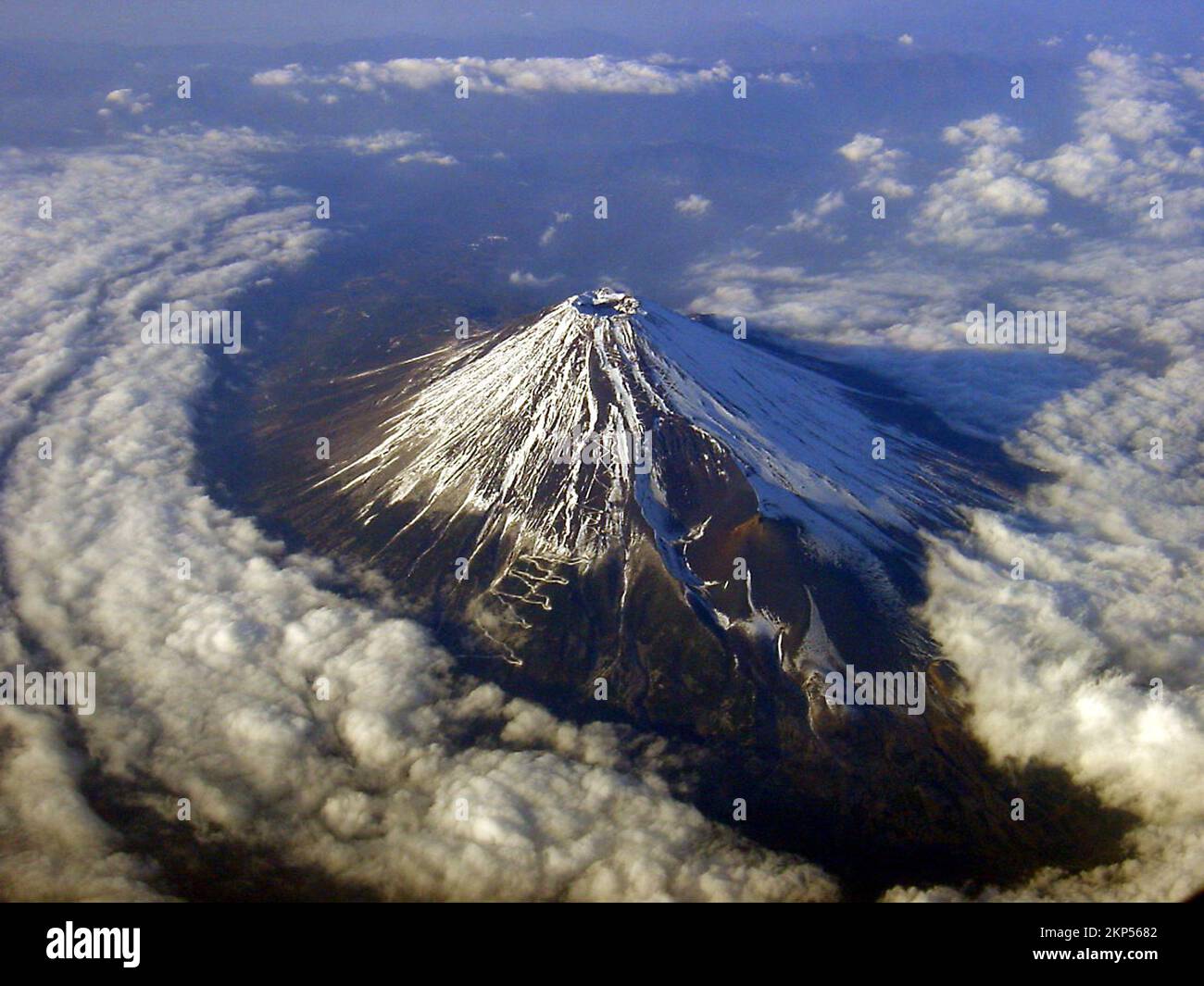 An aerial view of the Mount Fuji surrounded with fluffy white clouds ...