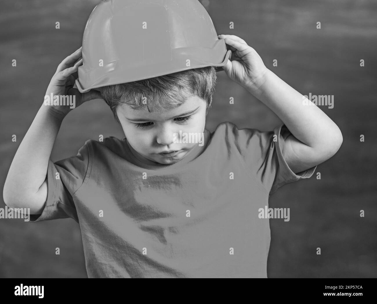 Boy play as builder or architect. Kid boy in orange hard hat or helmet ...