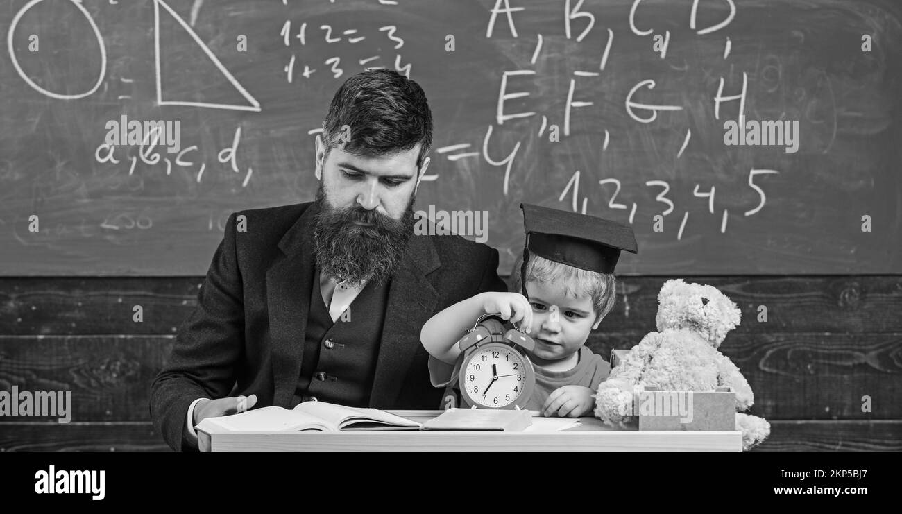 Bored kid play with clock. Individual studying concept. Teacher in ...