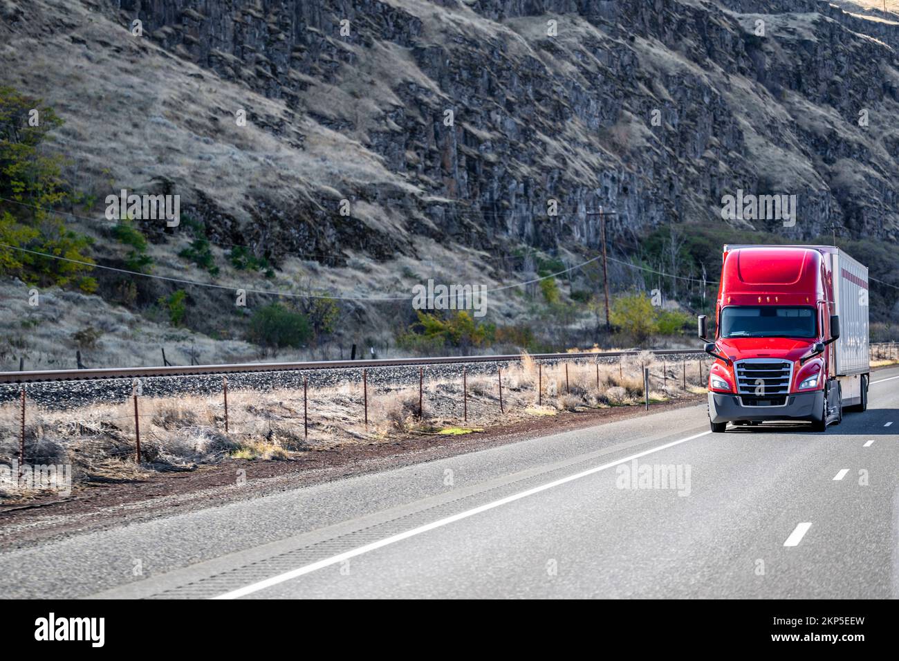 Industrial Bright red long haul big rig semi truck transporting cargo ...