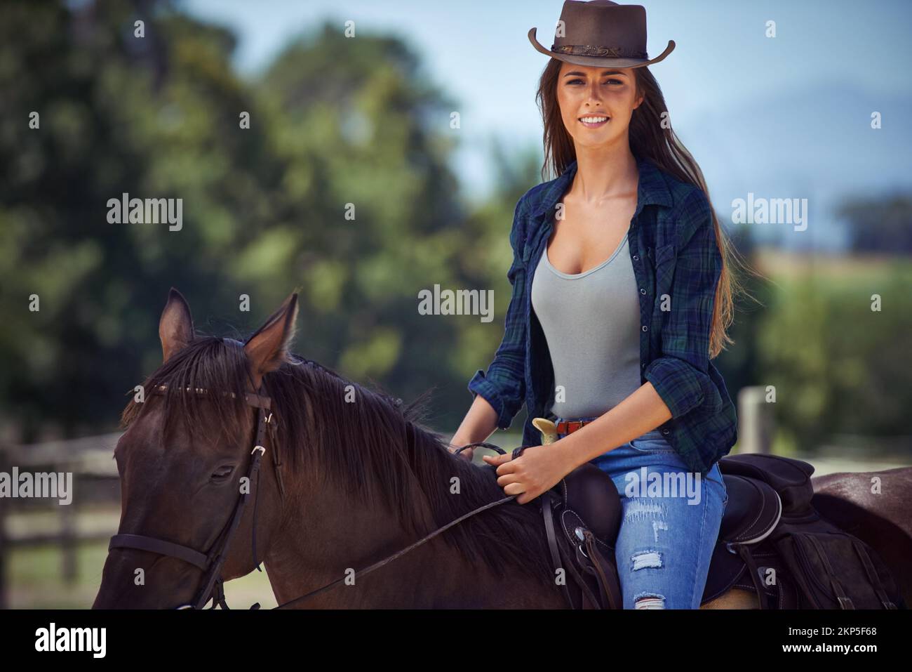 Loving the outdoors. Portrait of a gorgeous cowgirl with her horse Stock Photo - Alamy