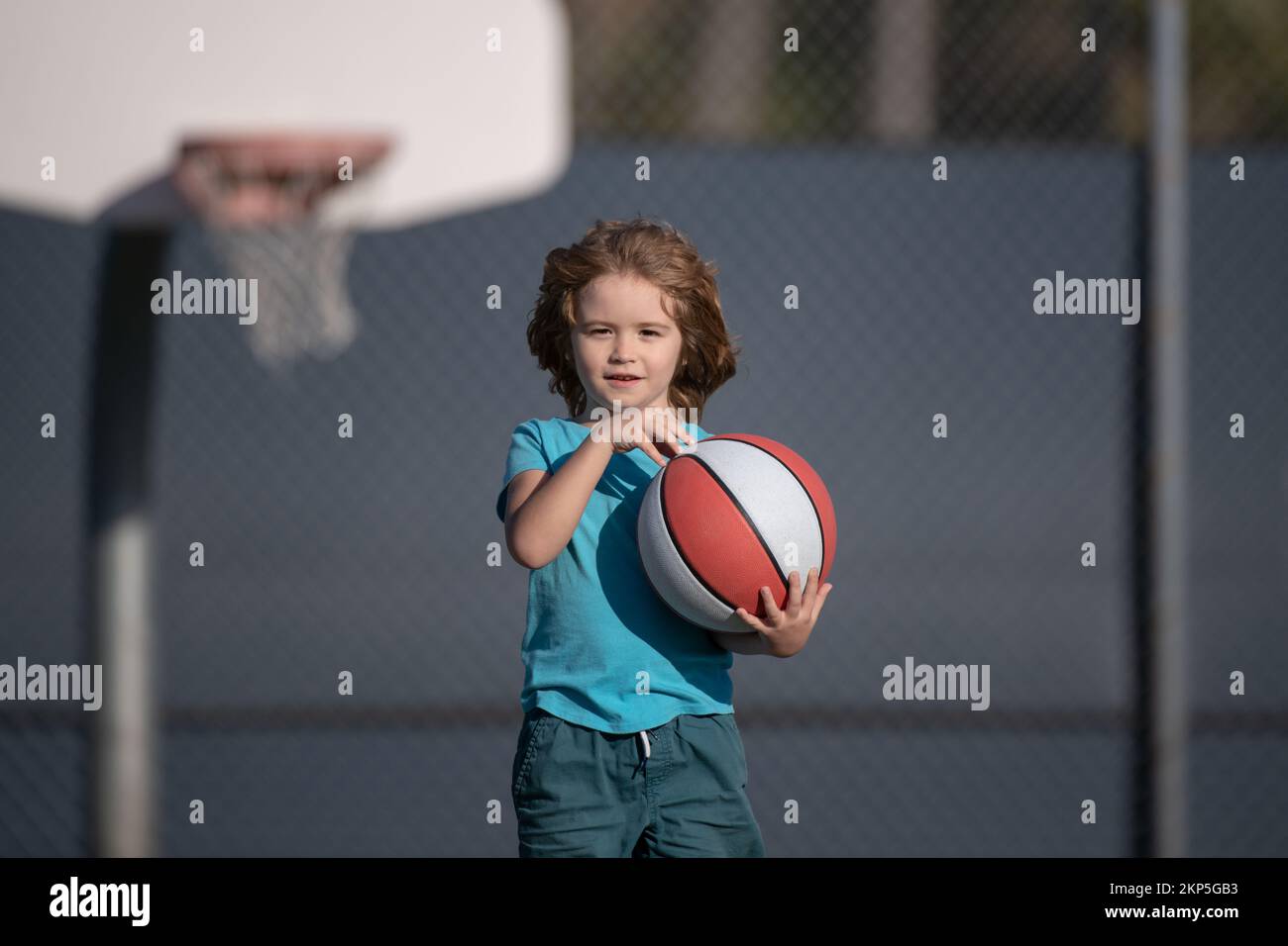 Little caucasian sports kid playing basketball holding ball with happy ...