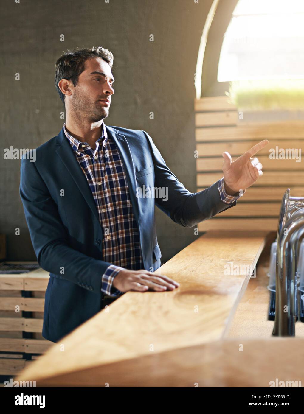 One more please. a young man ordering another beer at his local bar ...
