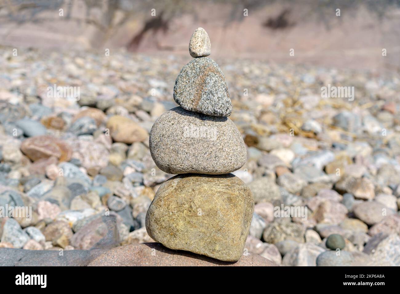 A closeup view of a pyramid of stones with unstable balance on the ...