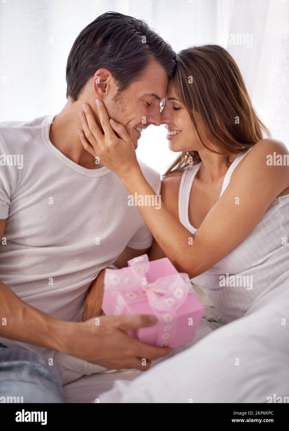 Keeping the romance alive. an affectionate young man giving his wife a ...