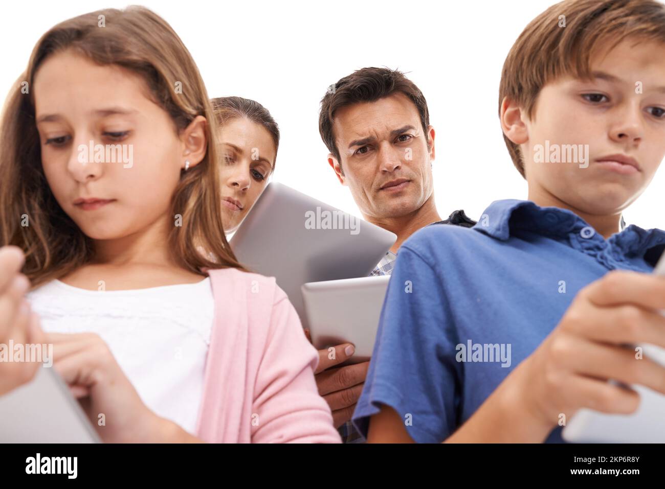 Lost in the online world. A family of four all using digital tablets ...
