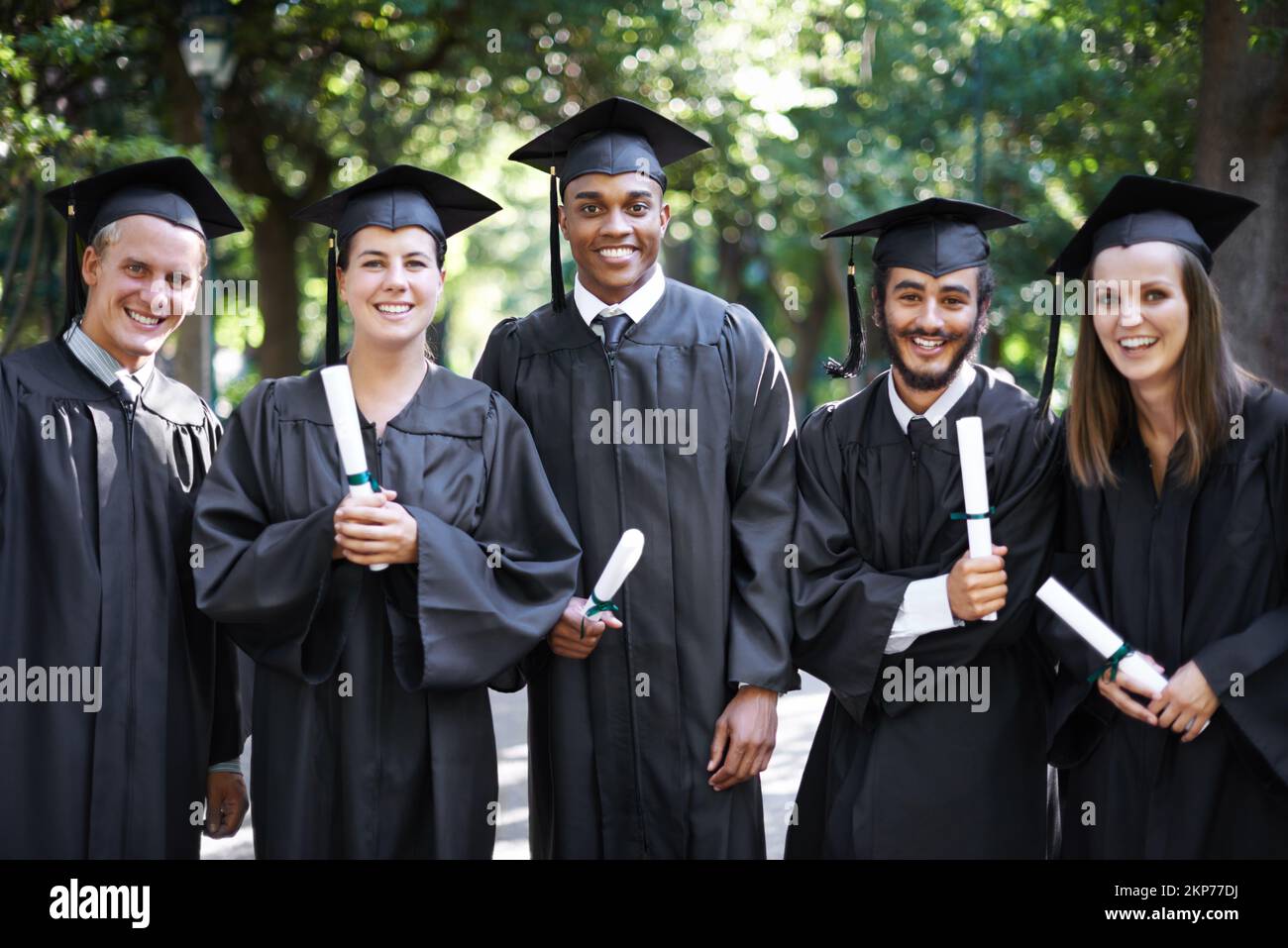 Theyre proud graduates. Portrait of a group of happy students holding ...