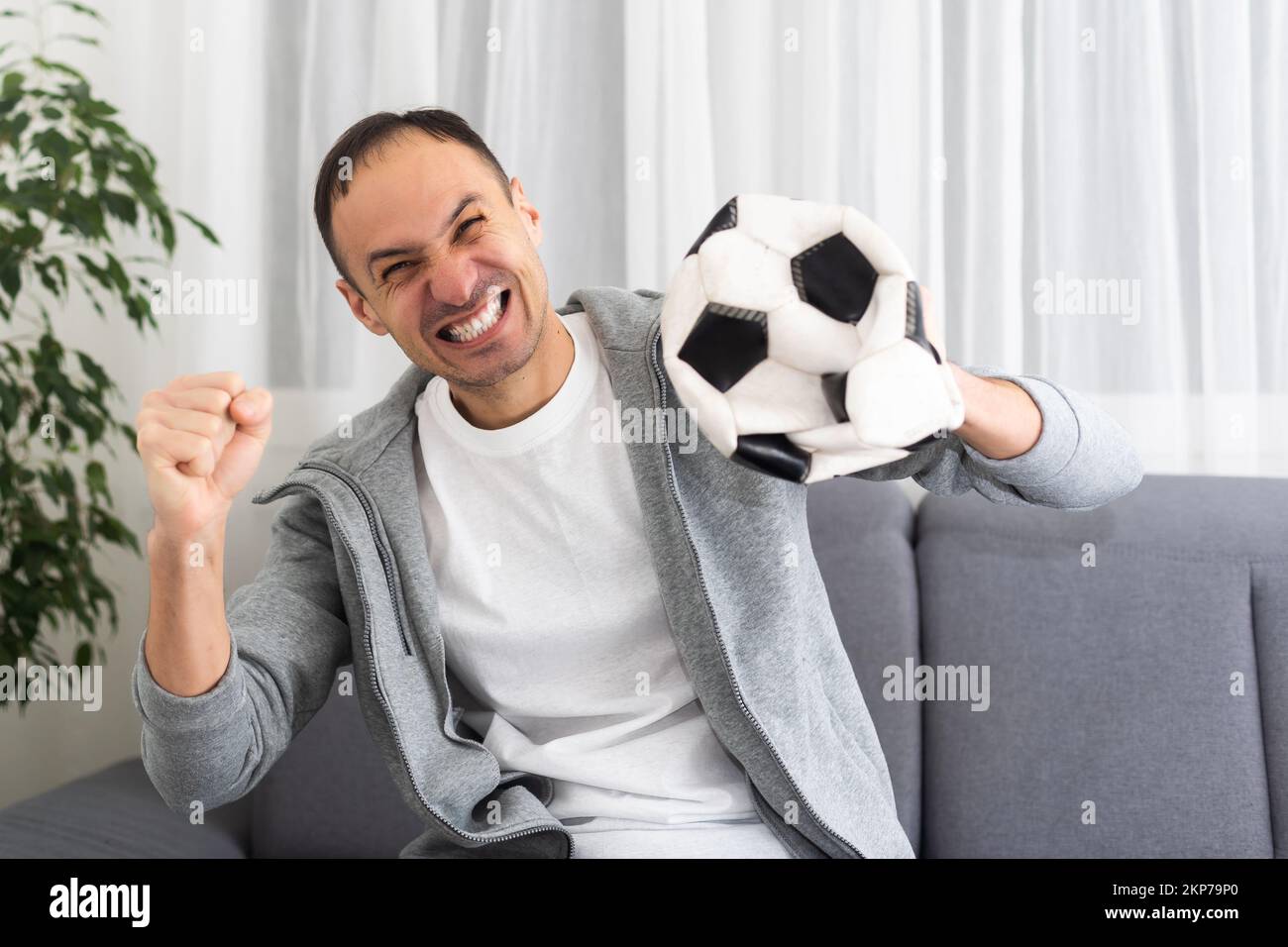 Football fan watching sport game supporting team raising hands after ...
