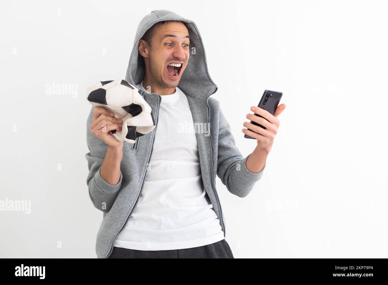 Handsome player man playing soccer holding football ball over ...