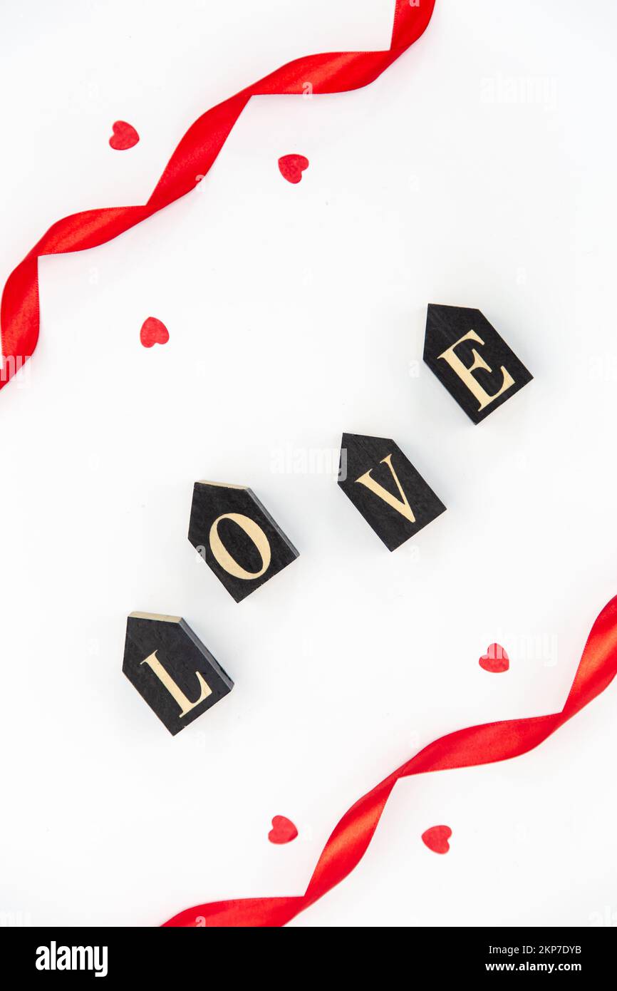 Decorative word love and red ribbons on a white background isolated ...