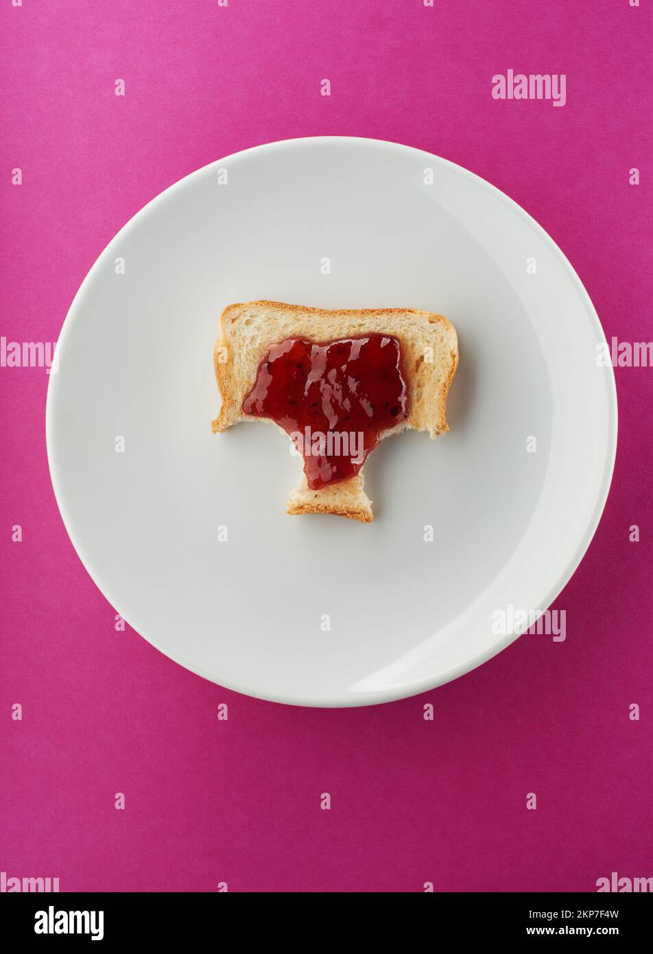 Crispy slice of toast with strawberry jam and two bites missing on ...