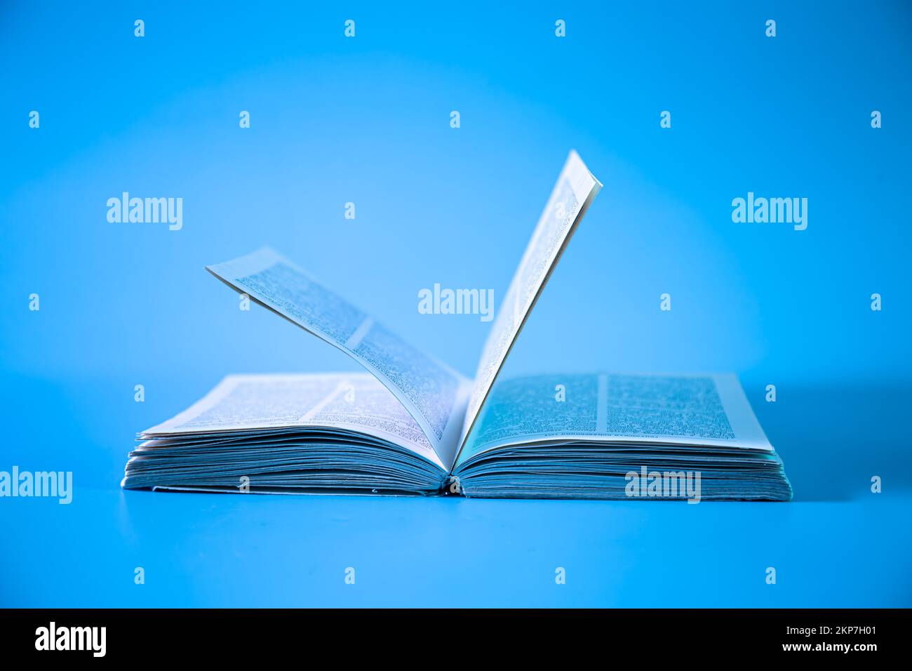 An open book on a blue background, isolated, close-up Stock Photo - Alamy