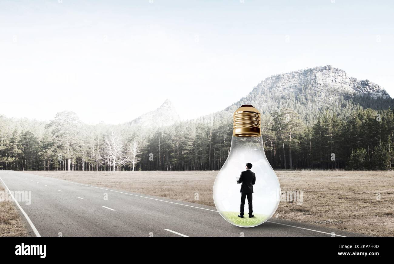 Businessman inside light bulb Stock Photo - Alamy