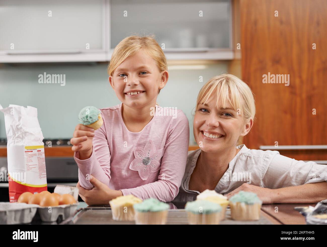 Baking together. an attractive young woman baking with her adorable ...