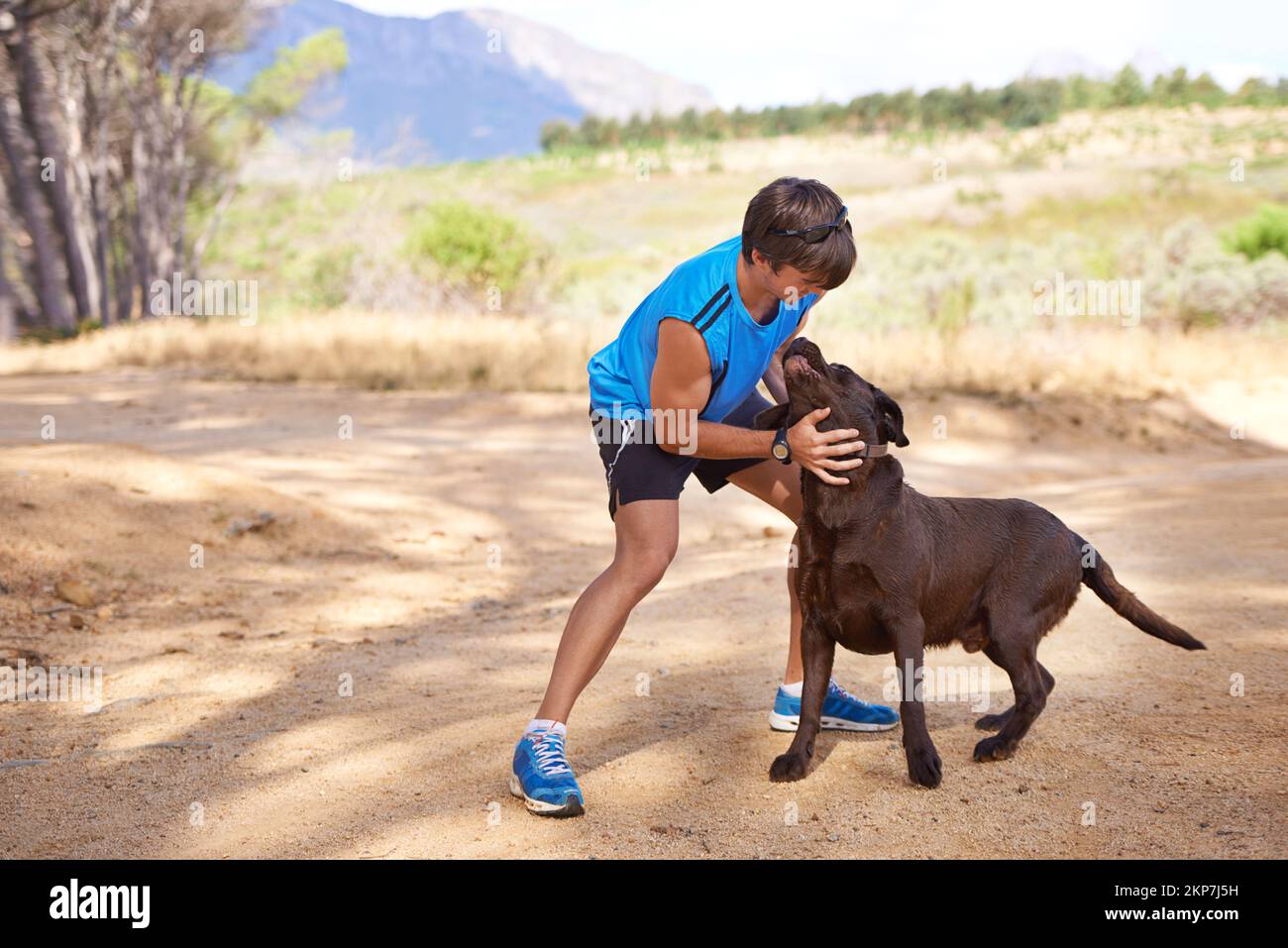 Dogs need their exercise too. a young man exercising outdoors with his ...