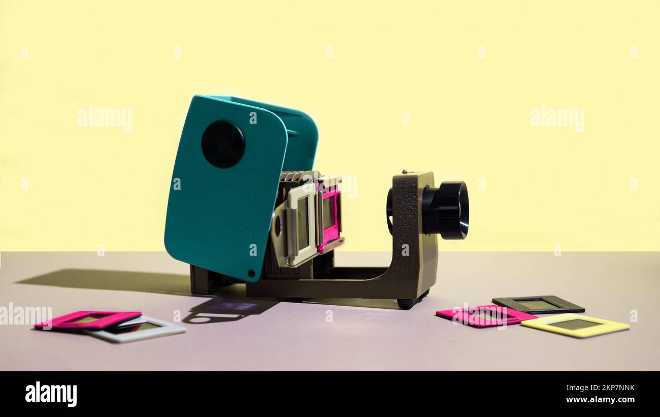 Vintage green -blue slide projector shows blured old slide on dark ...