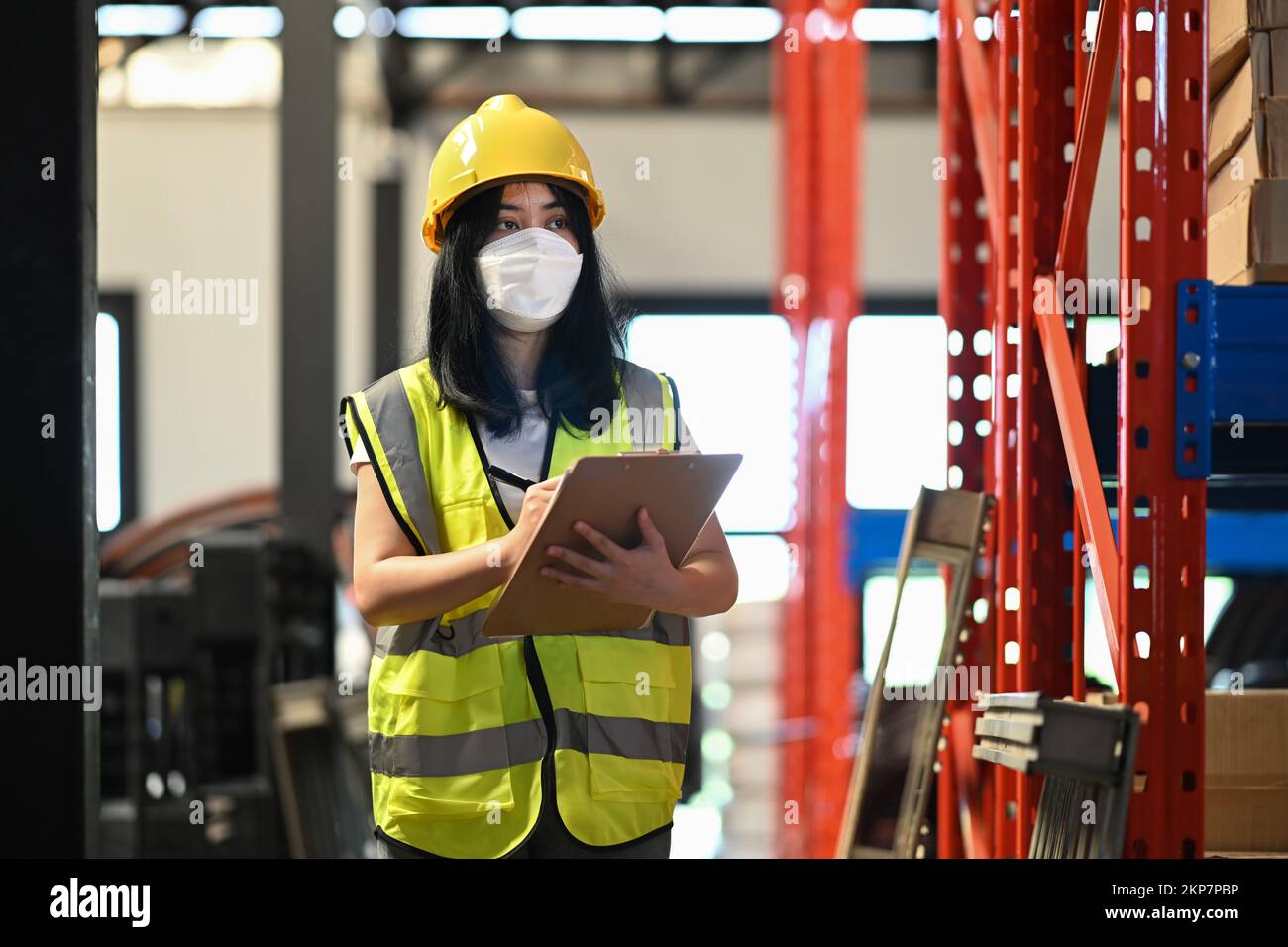 Female warehouse workers standing between retail warehouse full of ...