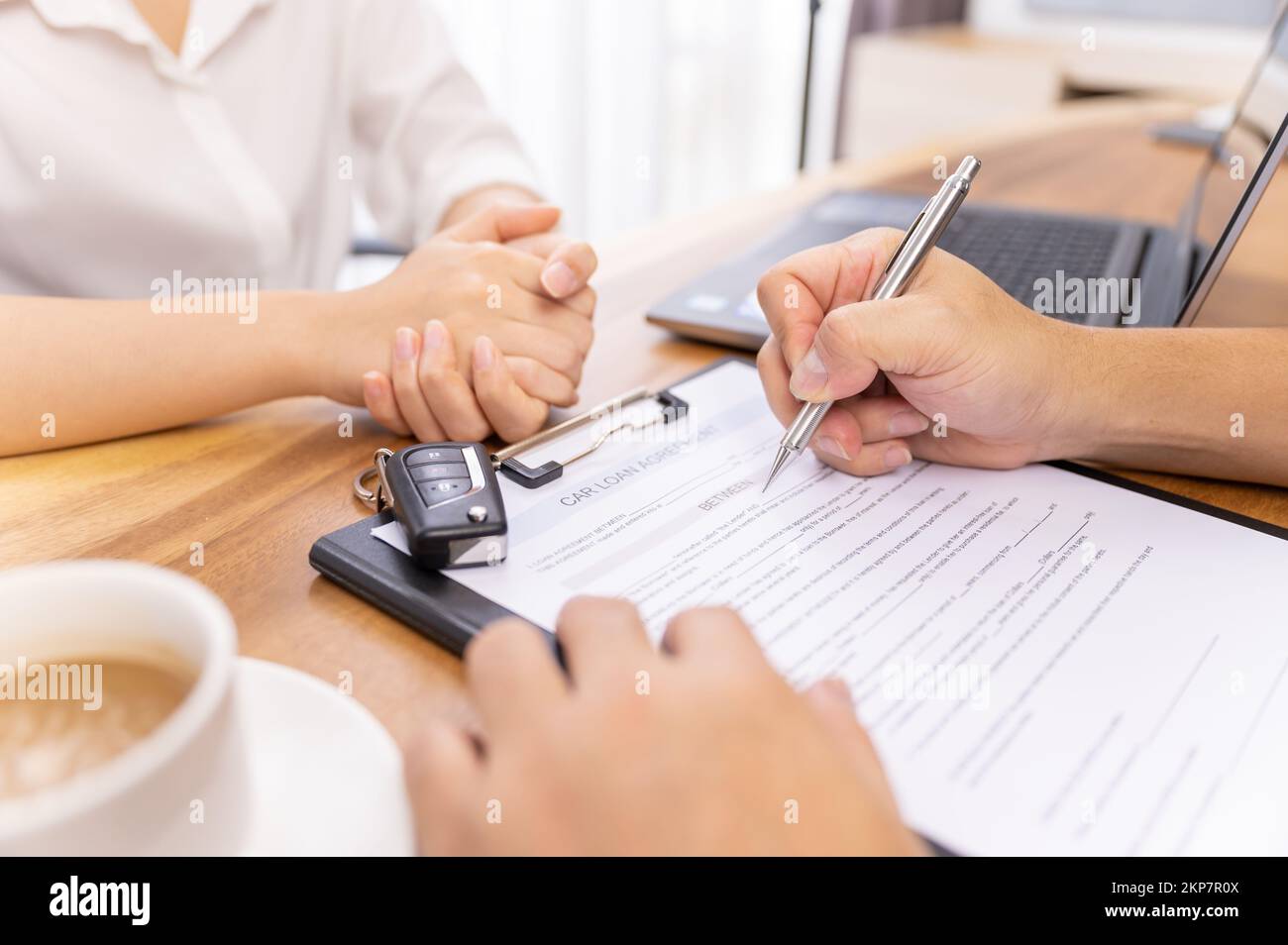 A woman's hand signing a car loan contract agreement Stock Photo - Alamy