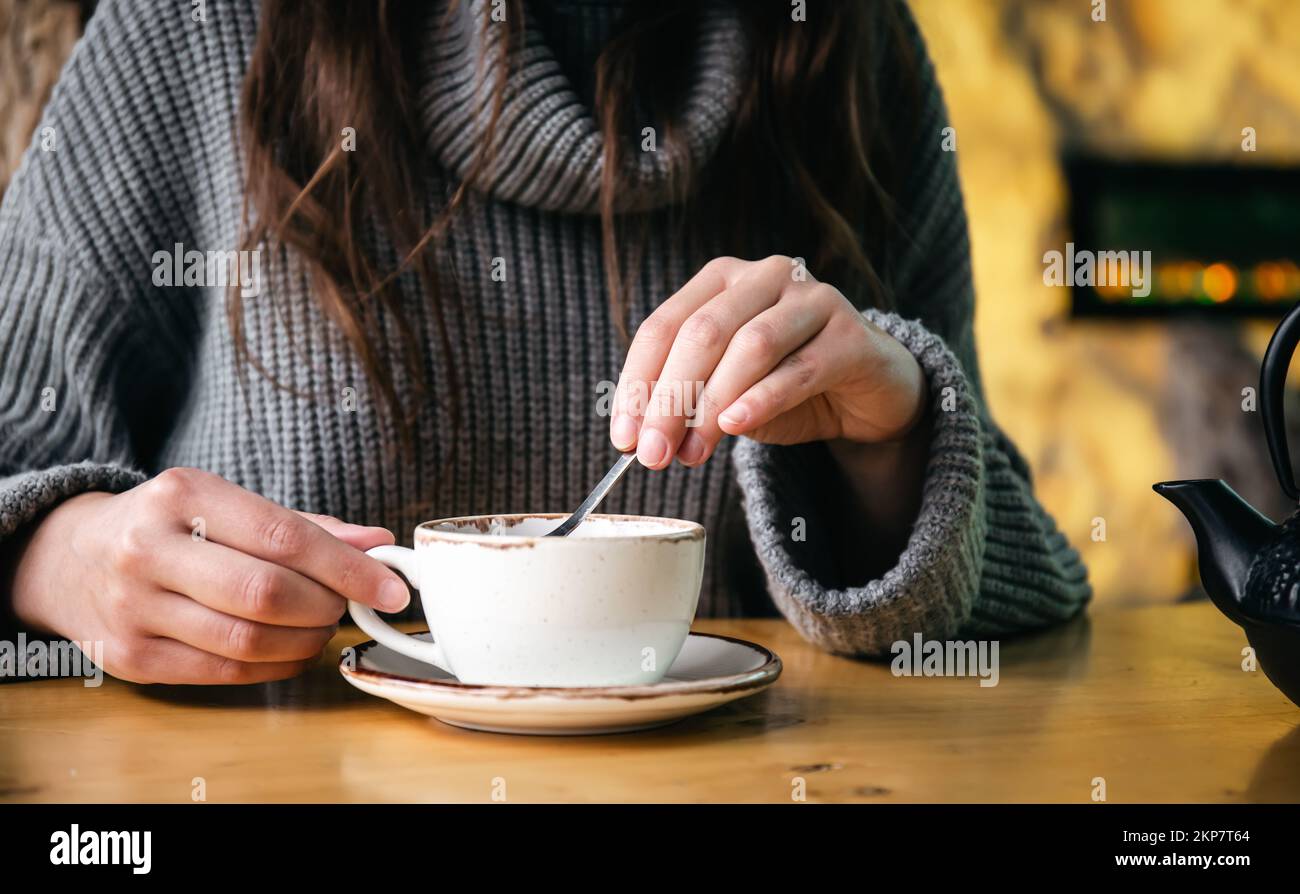 A woman drinks tea, stirs sugar with a spoon Stock Photo - Alamy