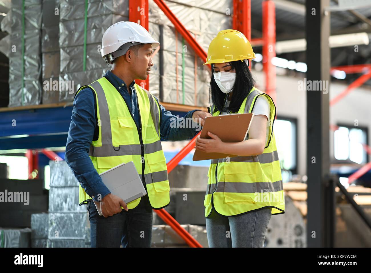 Warehouse workers are working in the retail warehouse full of shelves ...