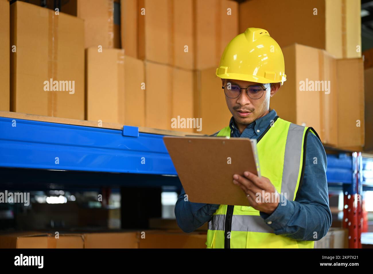 Focused male manager checking quantity of storage product while ...