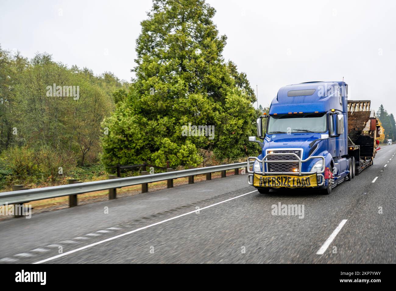 Blue powerful big rig classic semi truck tractor with oversize load ...
