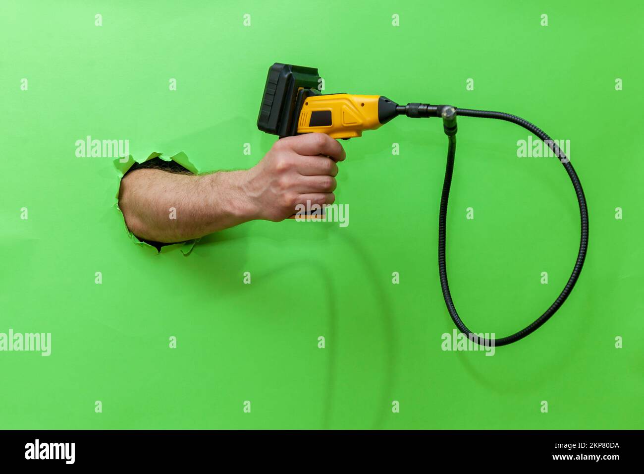 Endoscope camera in male hand isolated on green Stock Photo - Alamy