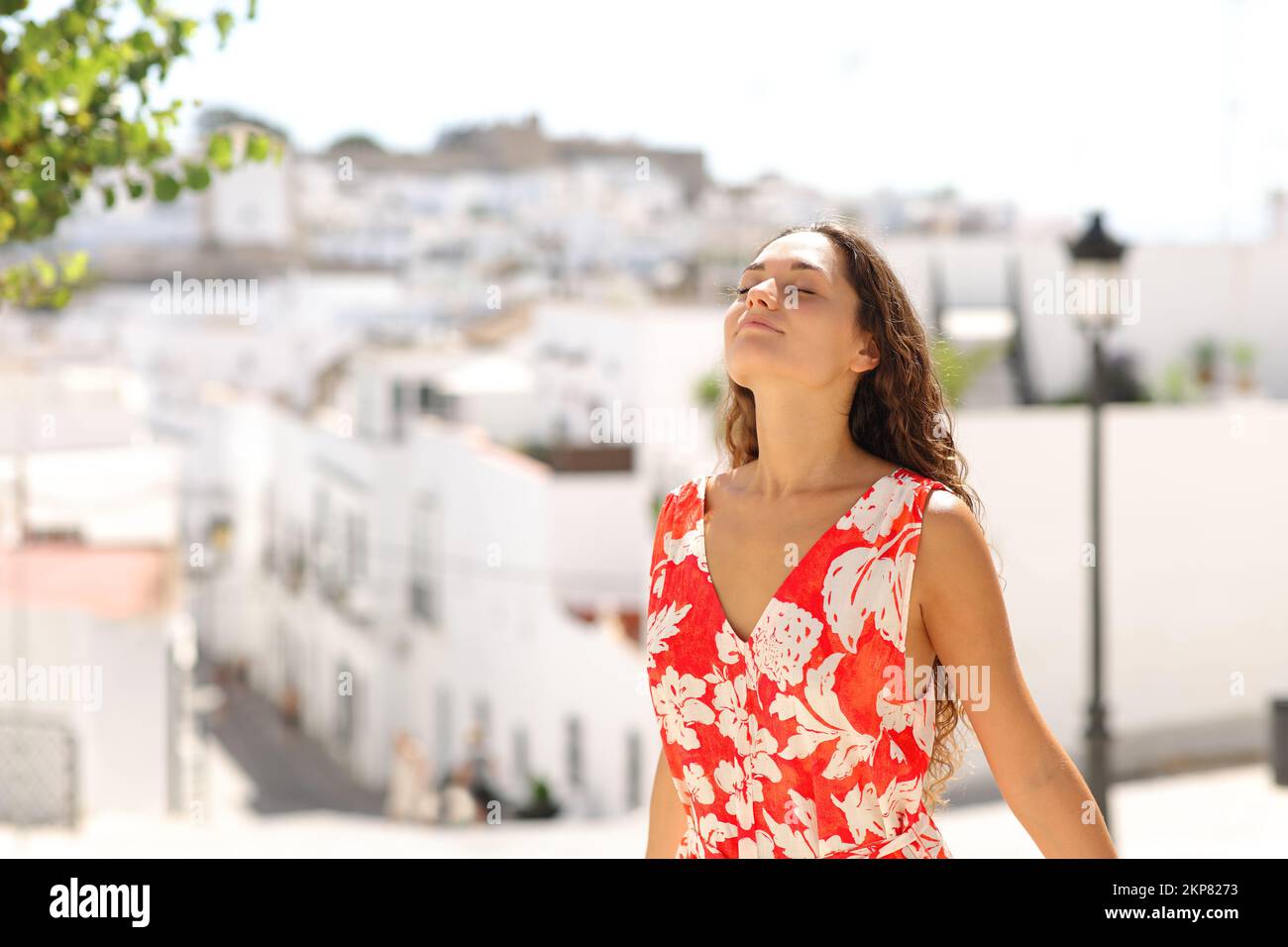 Relaxed tourist breaths fresh air in a white town on summer vacation ...