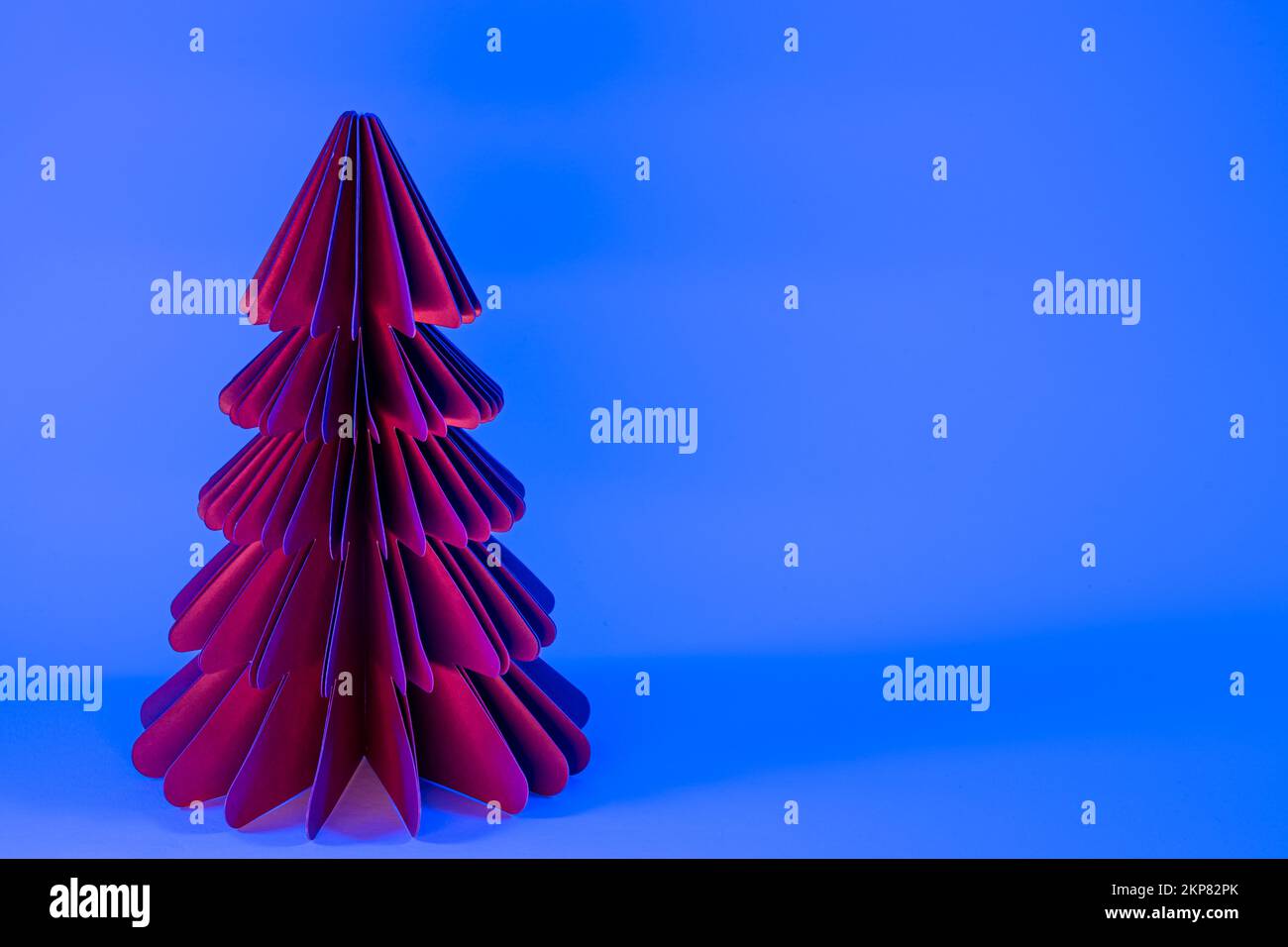 Decorative paper Christmas tree on blue background with trendy neon ...