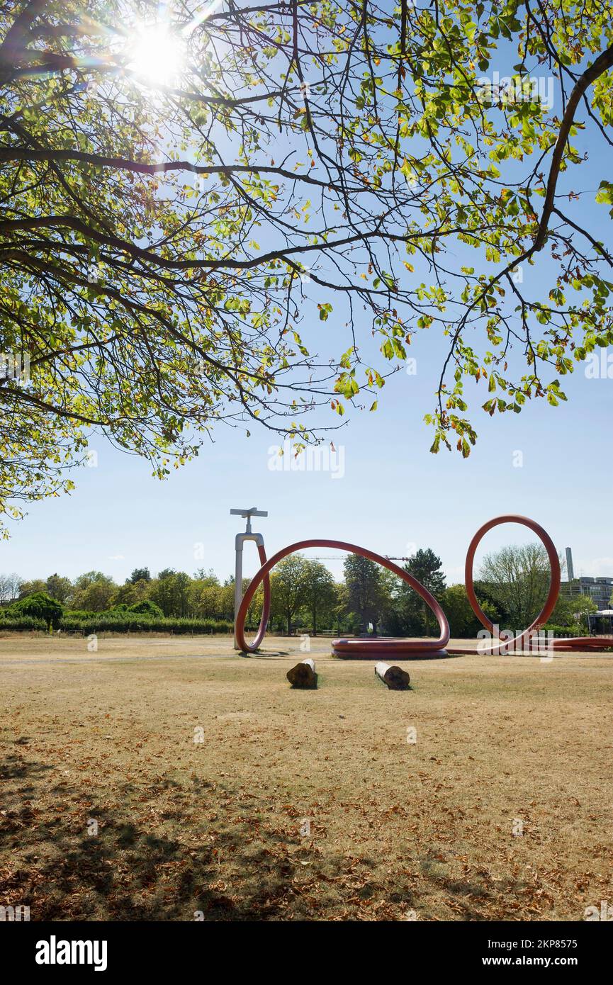 Withered meadow and sculpture of a water tap, climate change, heat ...