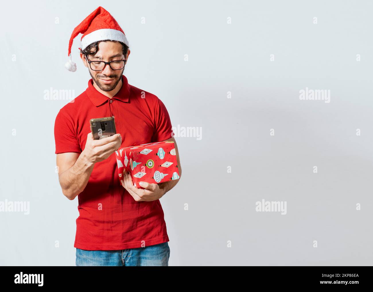 Christmas man holding gift box and telephone isolated. Handsome man in ...