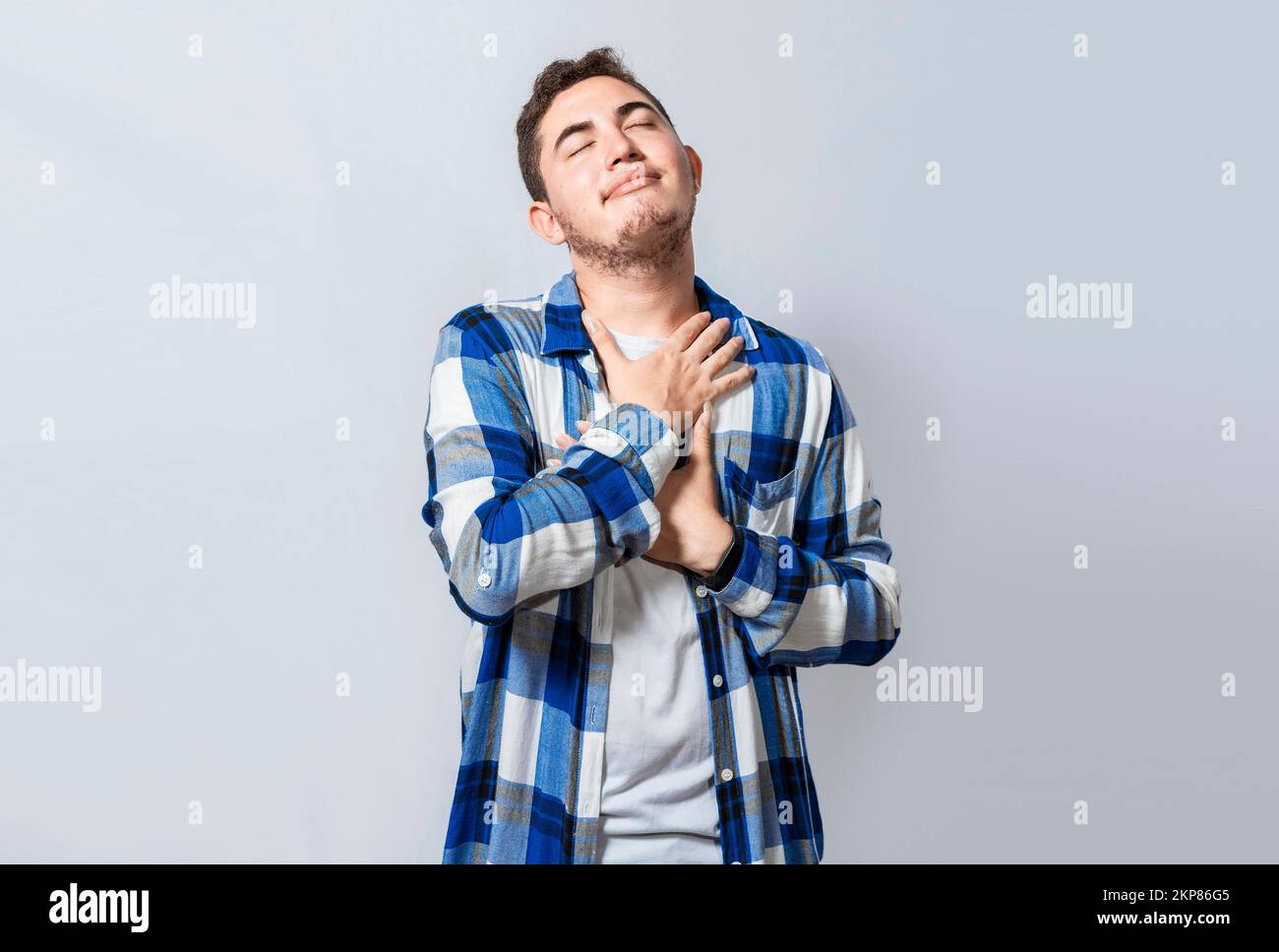 Grateful young guy smiling with hands on chest, isolated. Positive ...