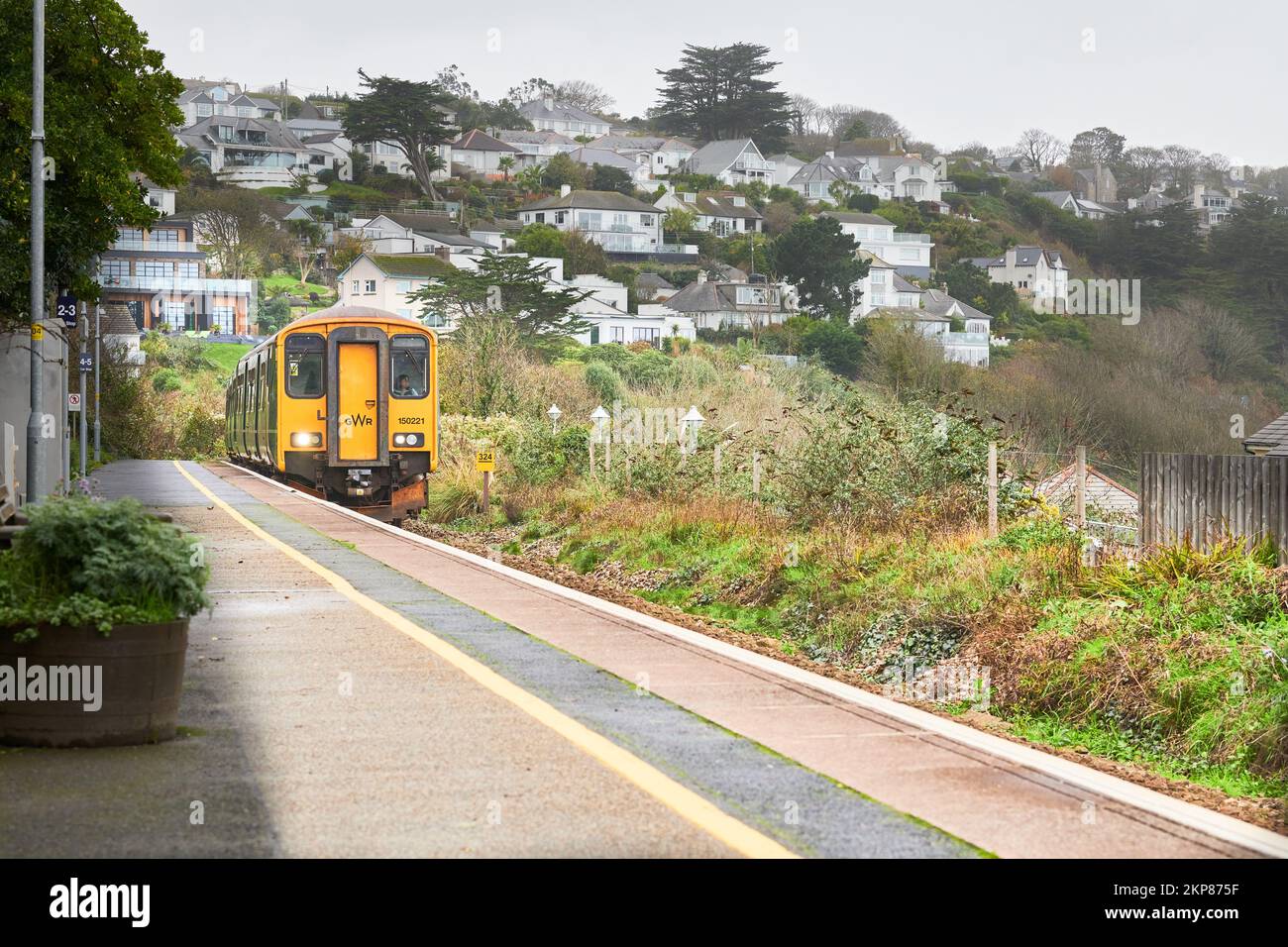A train on the single track railway line along the coast between St Ives and St Erth, Cornwall ...